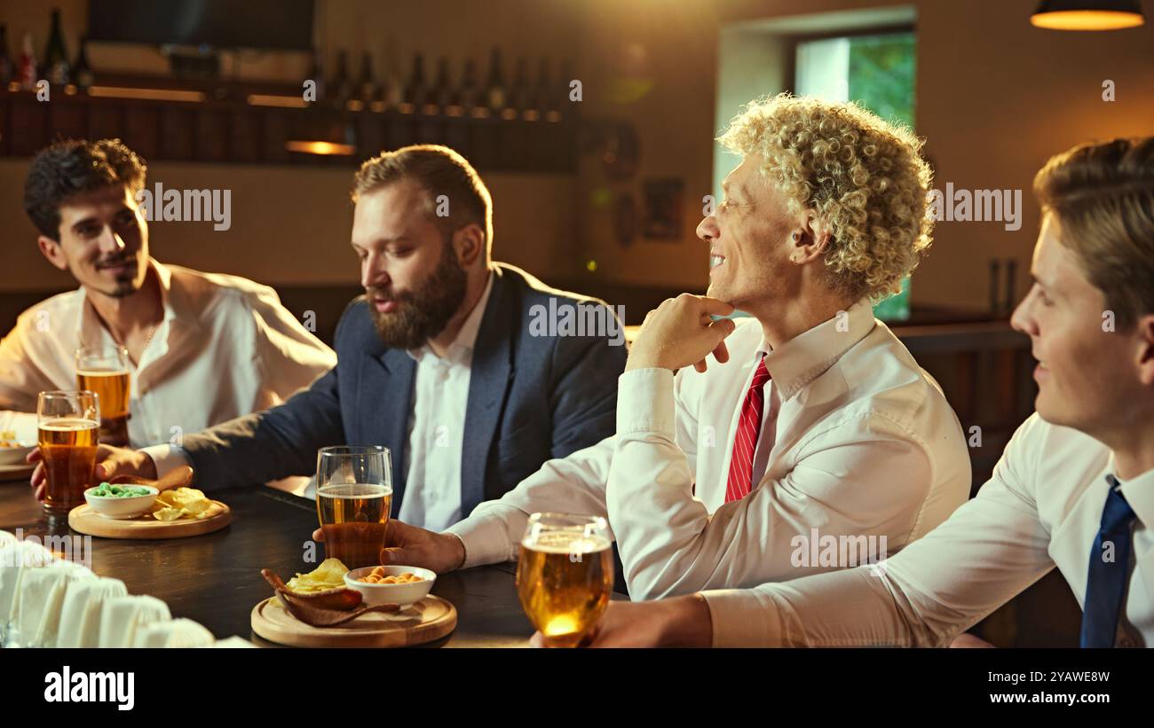 Casual and relaxed, group of colleagues enjoys evening, drink together ...