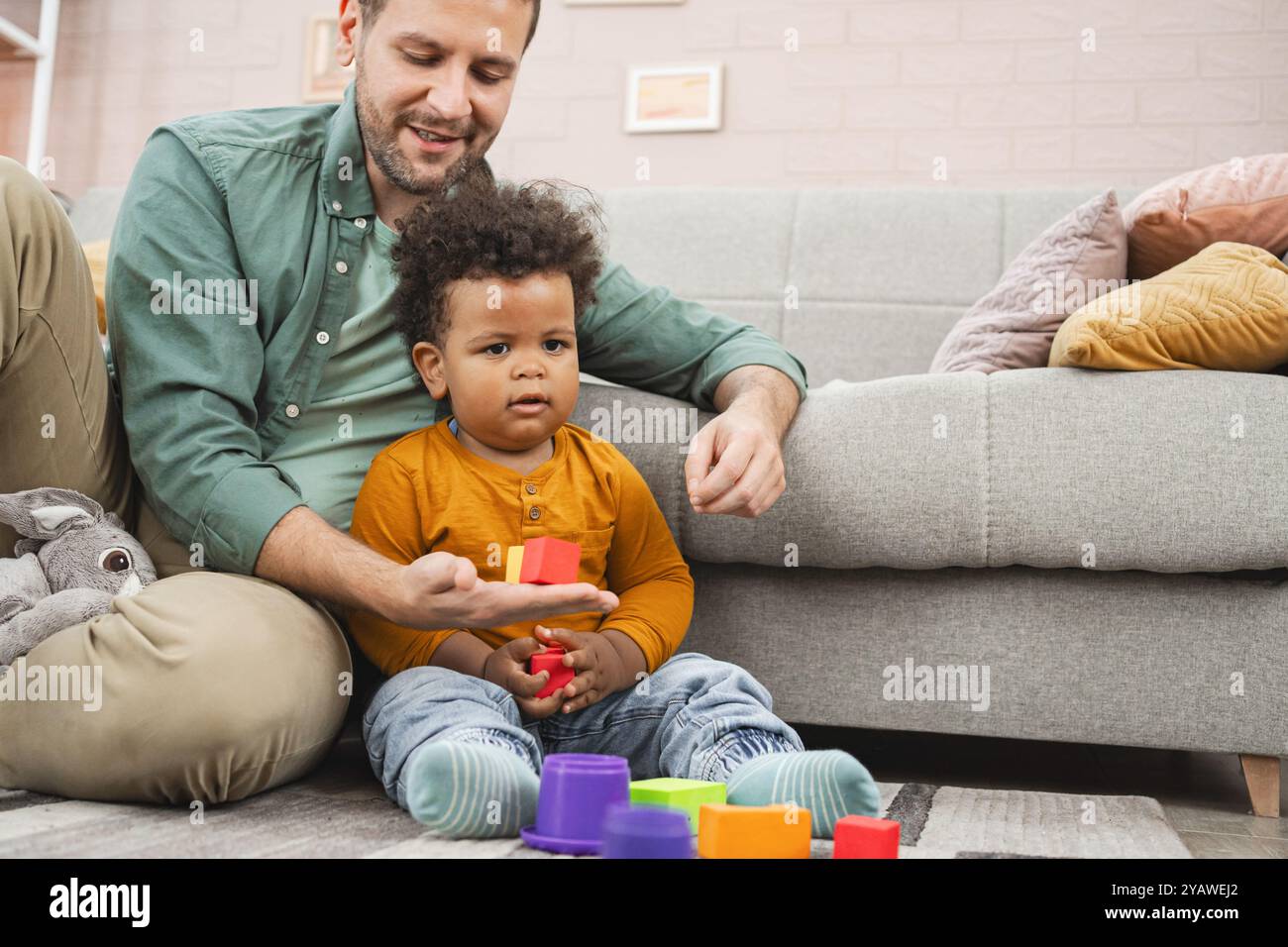 Multiracial family playing with colorful building blocks at home Stock ...