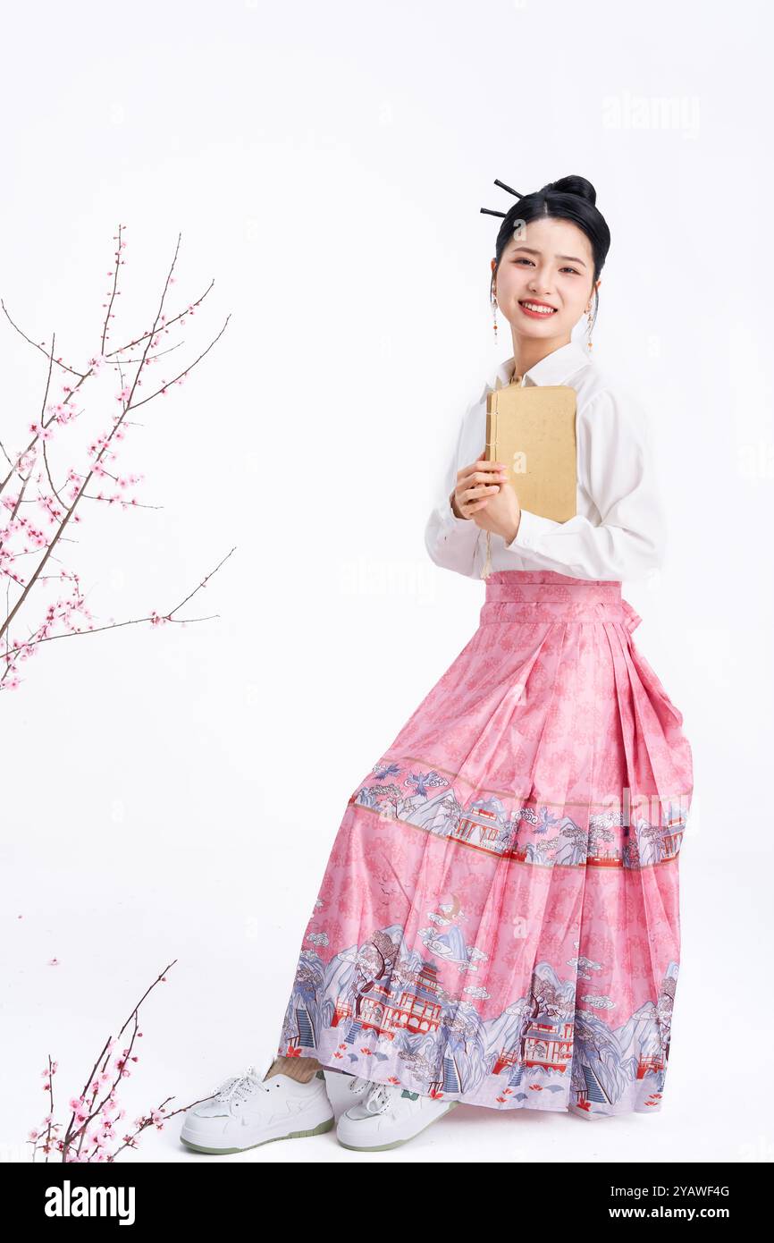 A young Chinese woman reading with a book in her hand Stock Photo - Alamy