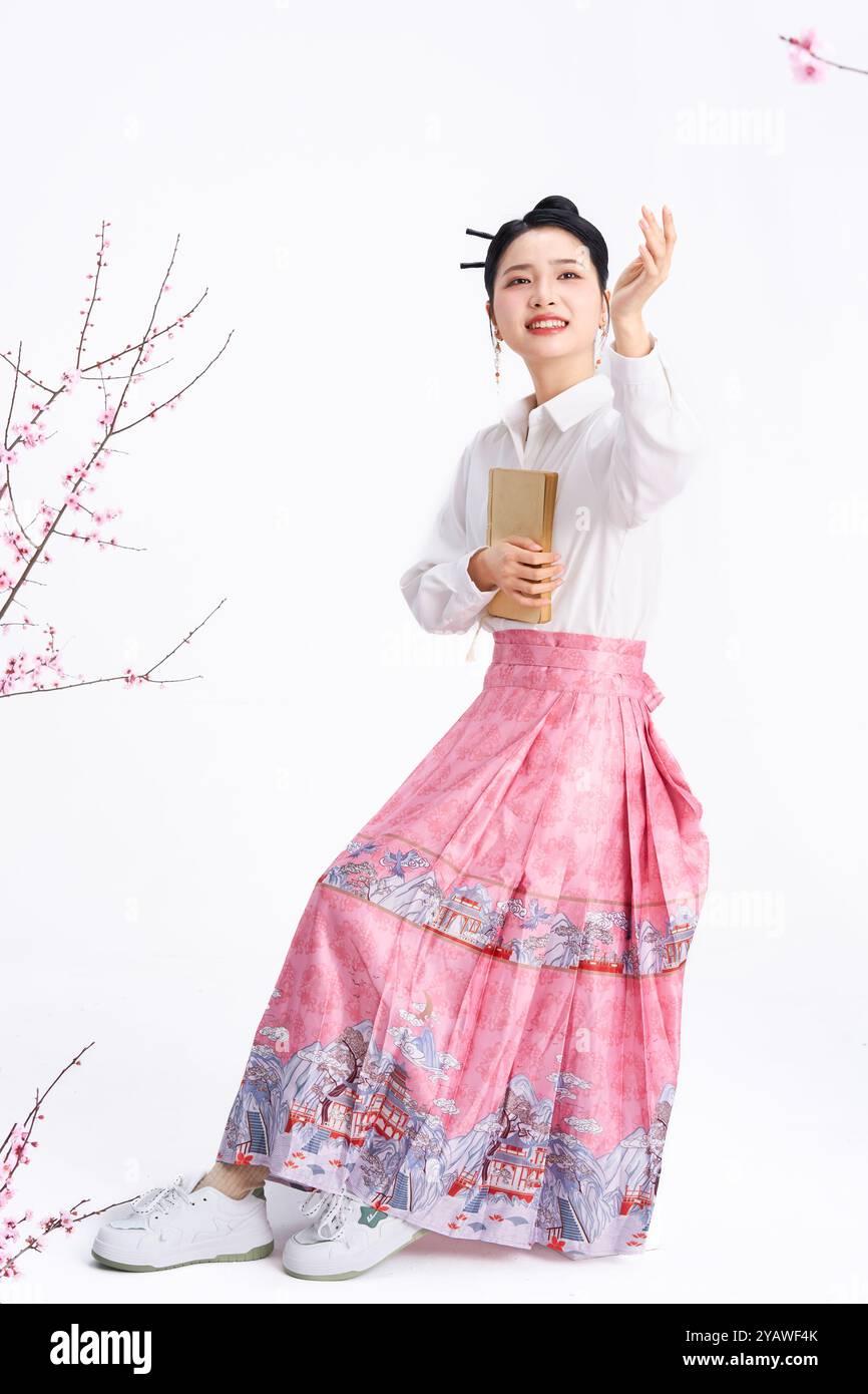 A young Chinese woman reading with a book in her hand Stock Photo - Alamy