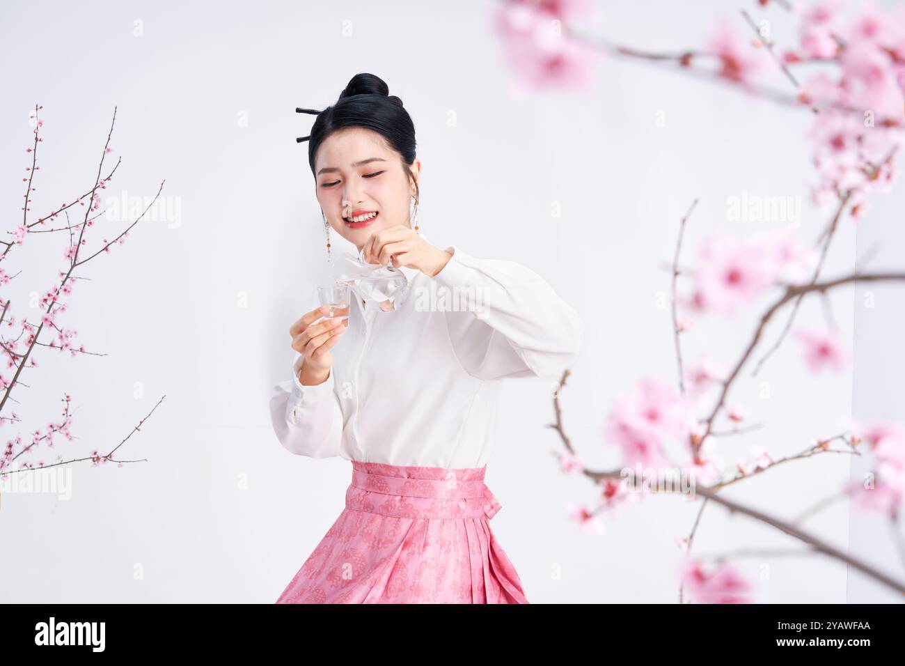 A young Chinese woman drinking tea under a flower tree Stock Photo - Alamy