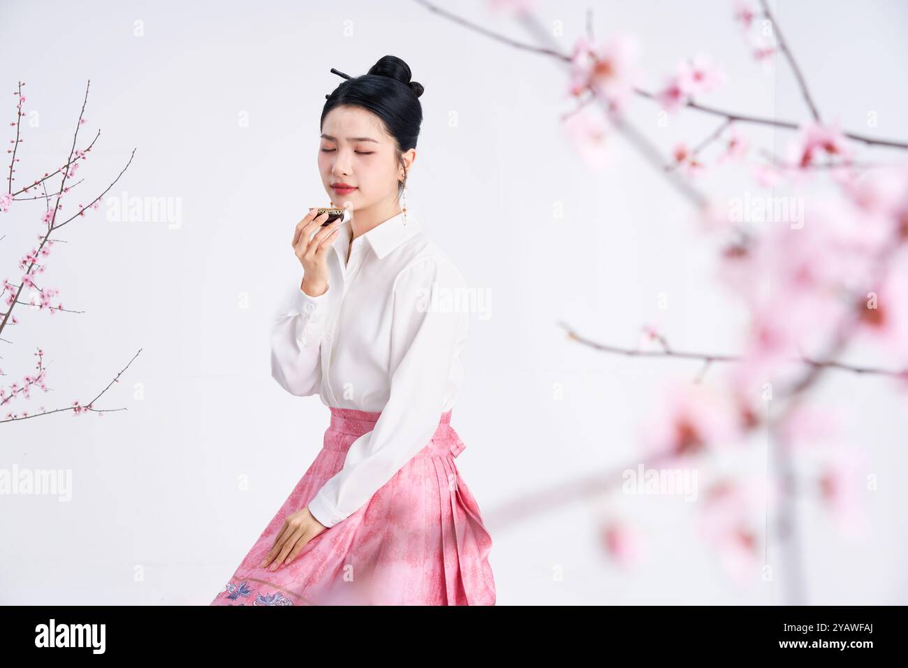 A young Chinese woman drinking tea under a flower tree Stock Photo - Alamy