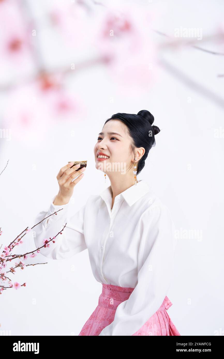 A young Chinese woman drinking tea under a flower tree Stock Photo - Alamy
