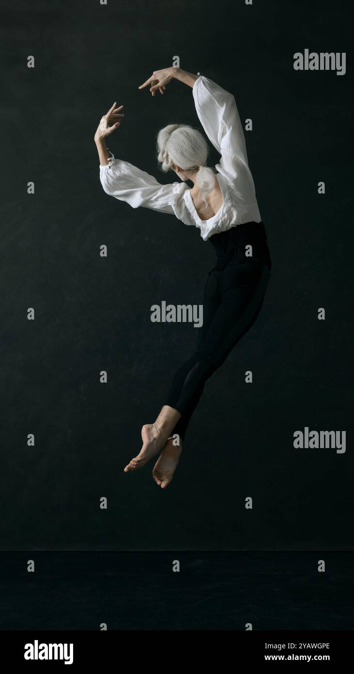 Dancer, in old garments, appears weightless as he leap, arms flowing ...