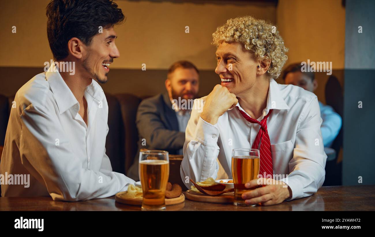 Friendly and relaxed conversation between colleagues at bar, smiles and ...