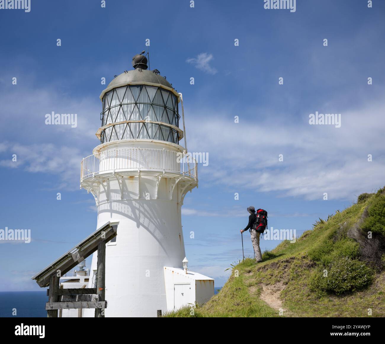 Hiker looking up at Cape Brett Lighthouse. Cape Brett Walkway. Bay of ...