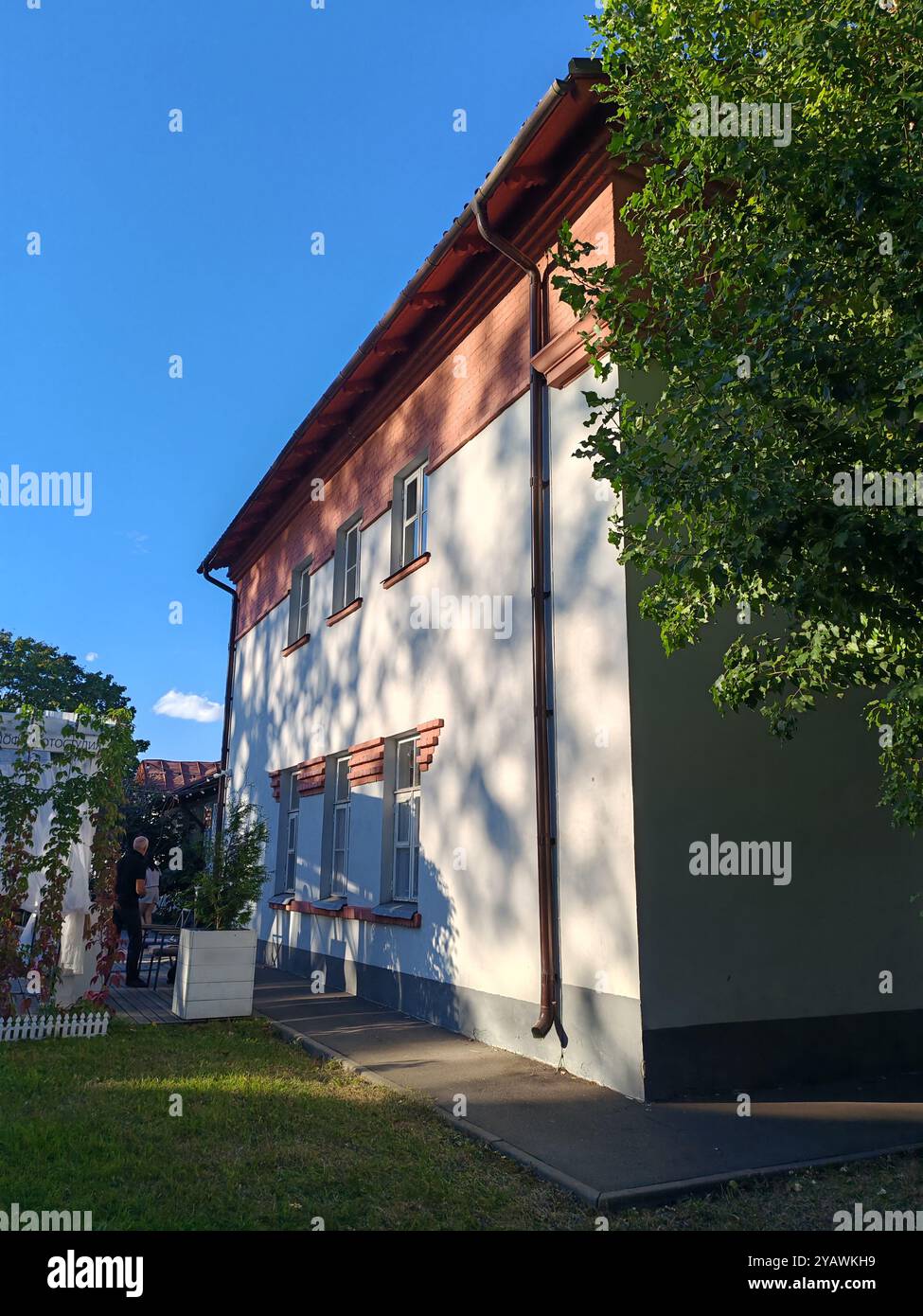 A traditional building with red accents and a tall, sloped roof, framed ...