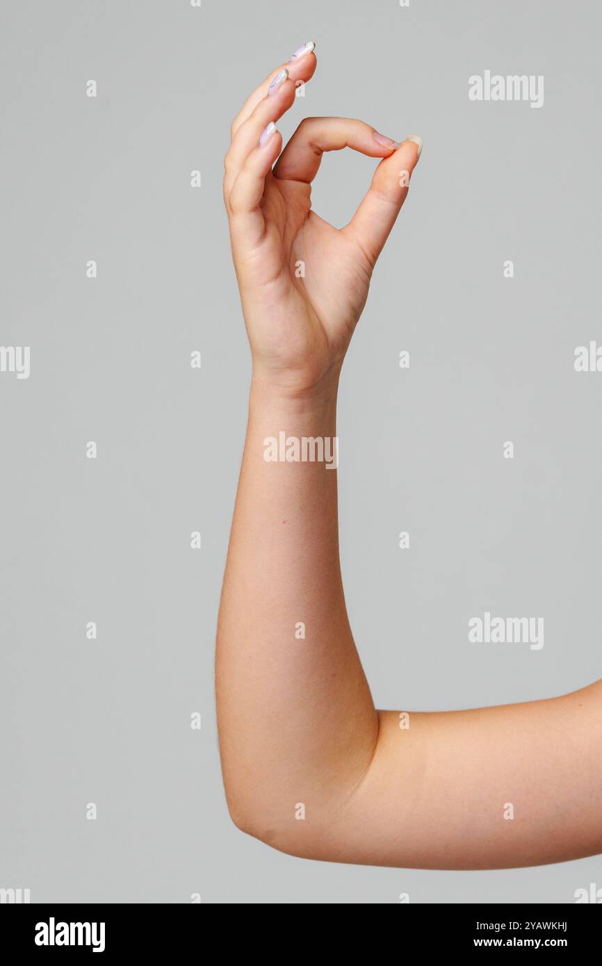 A hand gesturing the OK sign against a simple grey background Stock ...