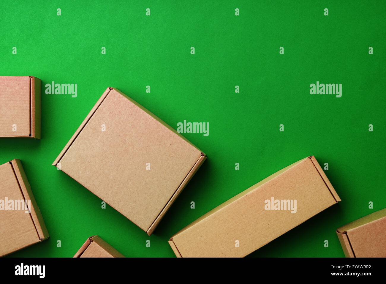 Brown cardboard boxes arranged on a vibrant green surface Stock Photo ...