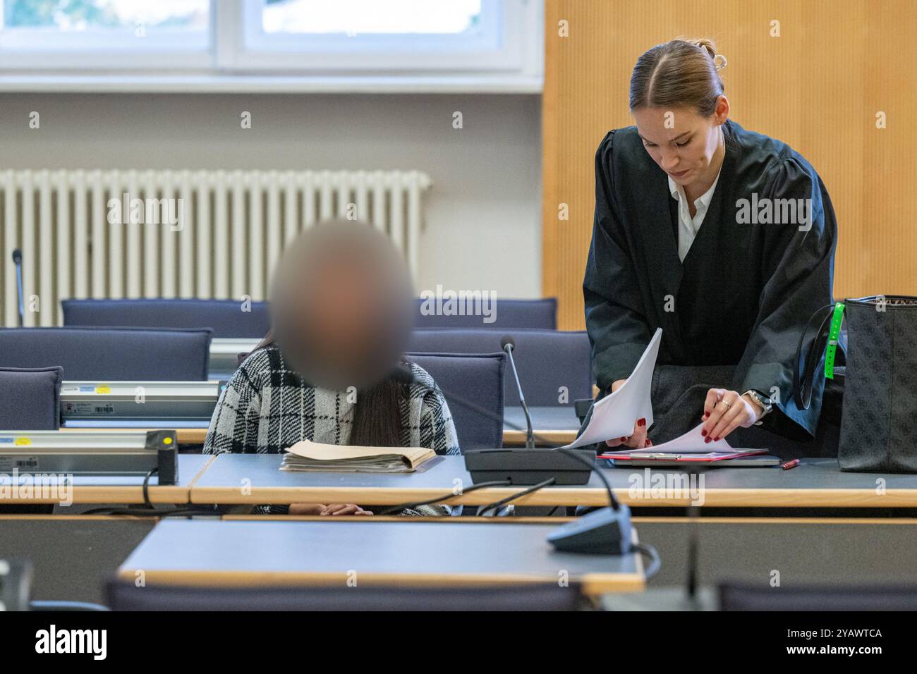 Regensburg, Germany. 16th Oct, 2024. The defendant (l) sits next to her ...