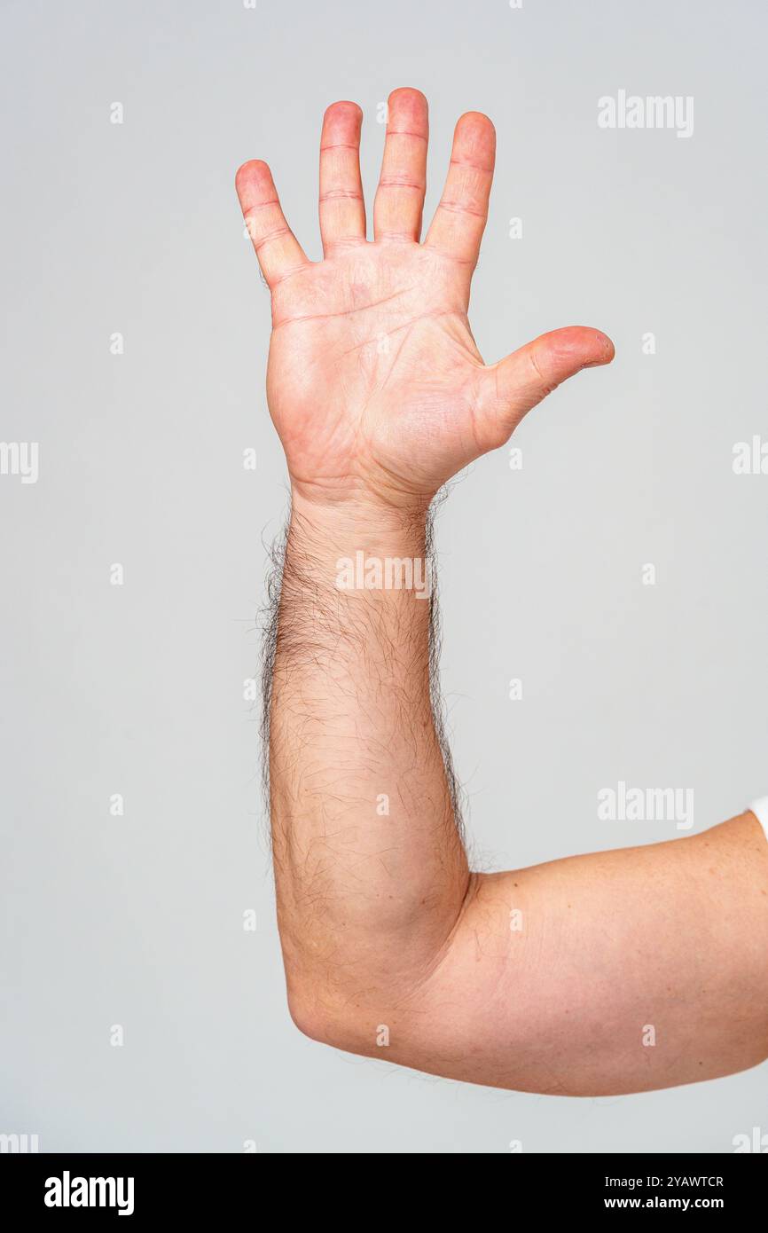 Hand raised in greeting against a plain background Stock Photo - Alamy