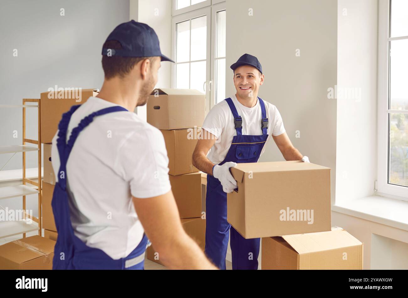 Cheerful employees of transportation and delivery company carry ...