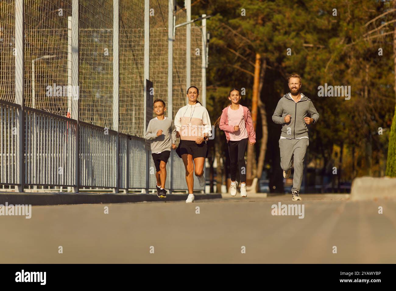 Happy active family in sportswear running together in the park having ...