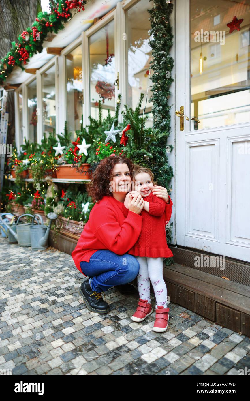 Little baby girl with mom joe in cafe at Christmas market. Happy ...