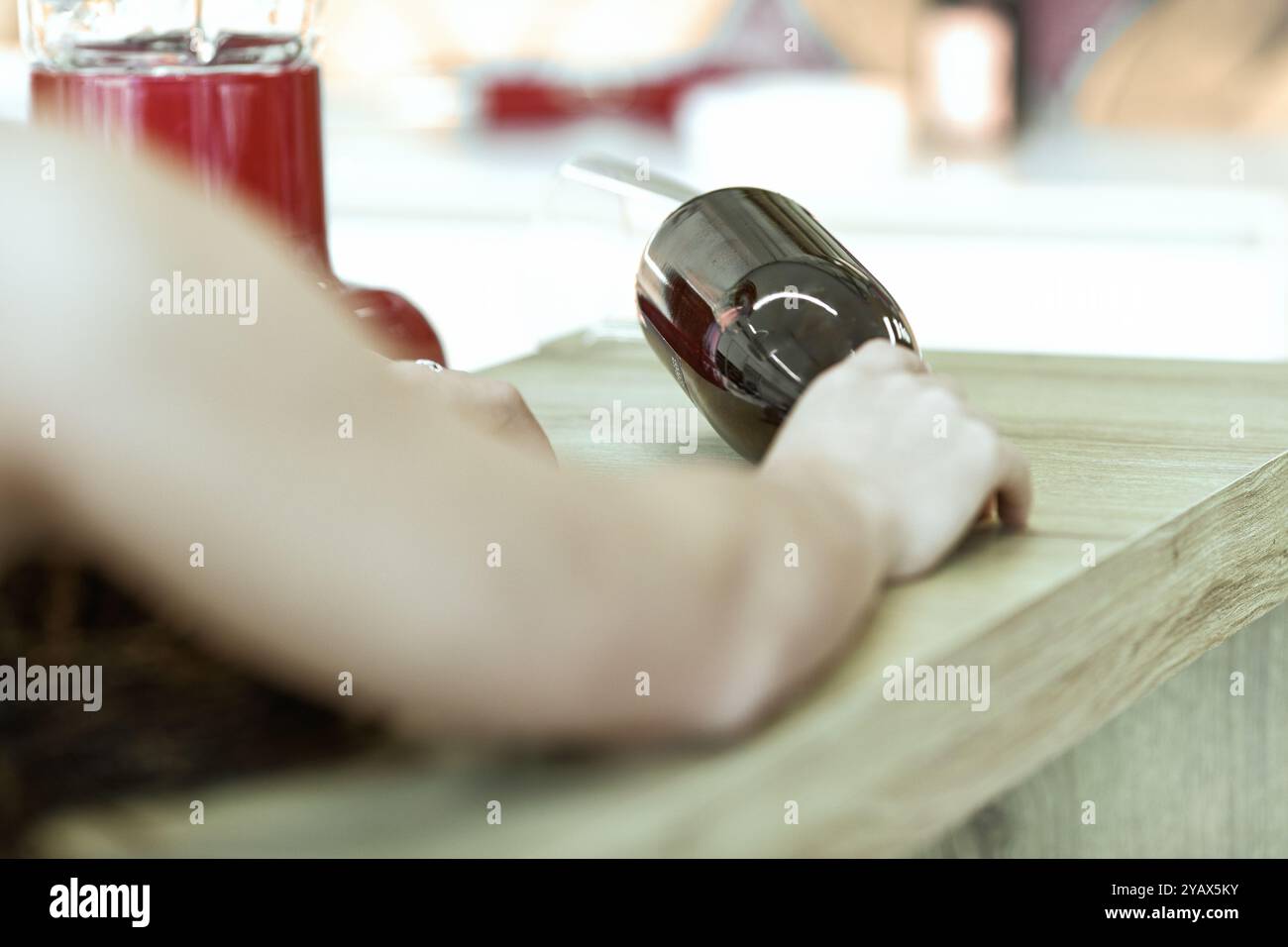 Young woman lies unconscious on a kitchen counter, reaching for spilled ...