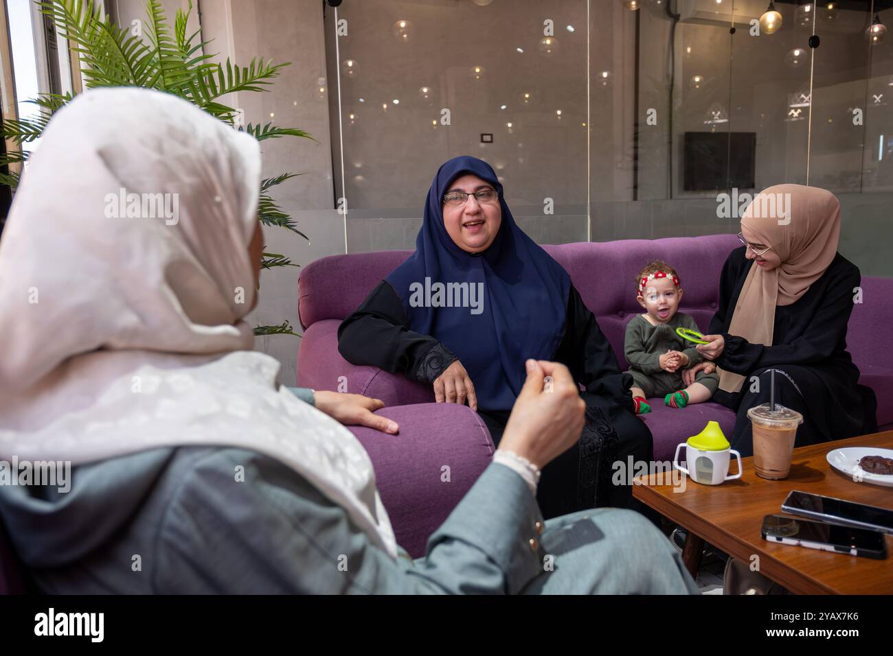 Multi generation group of arabic muslim females talking and having ...