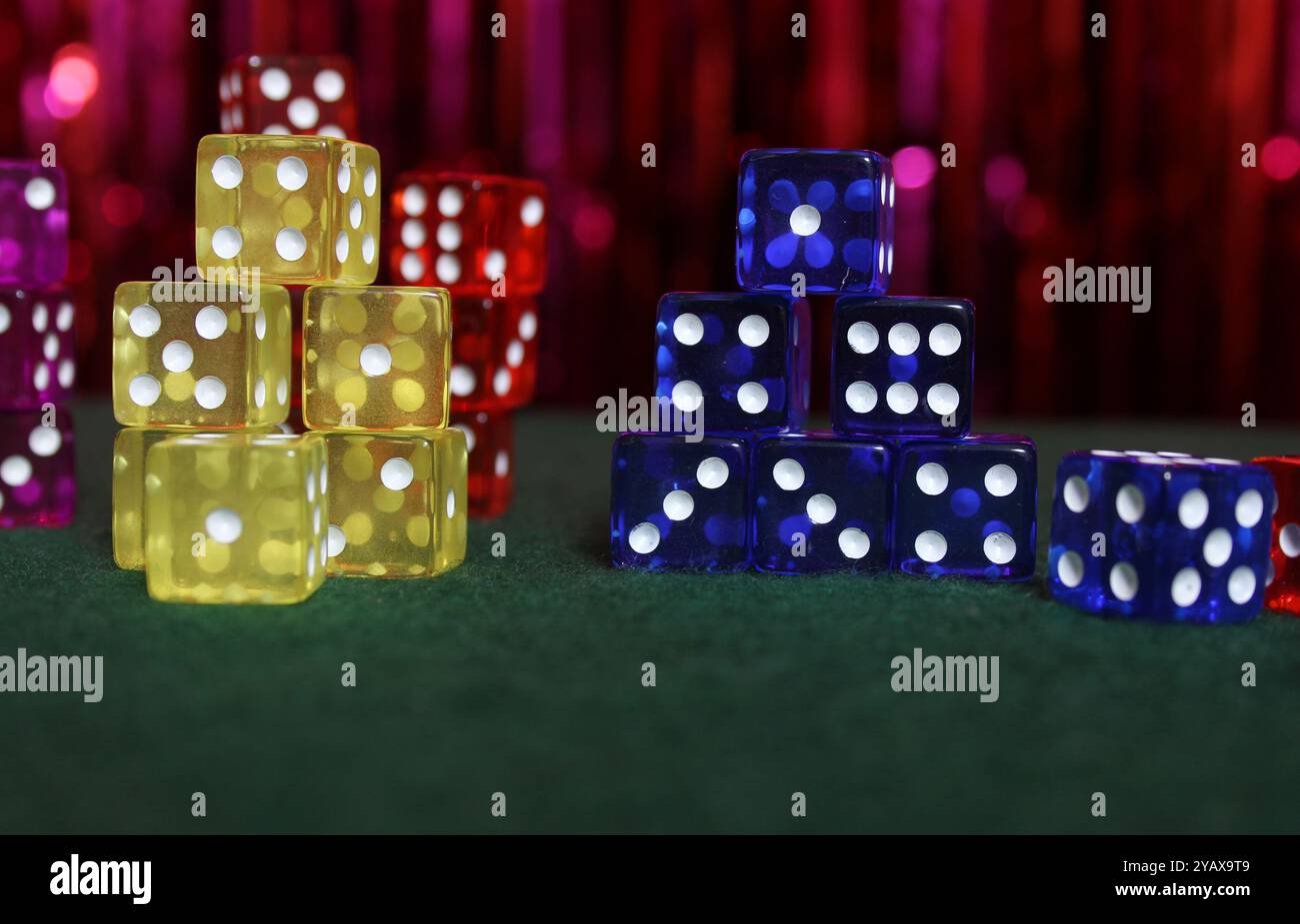Stacks of Colorful Dice on Green Felt With Pink Bokeh Background Stock ...