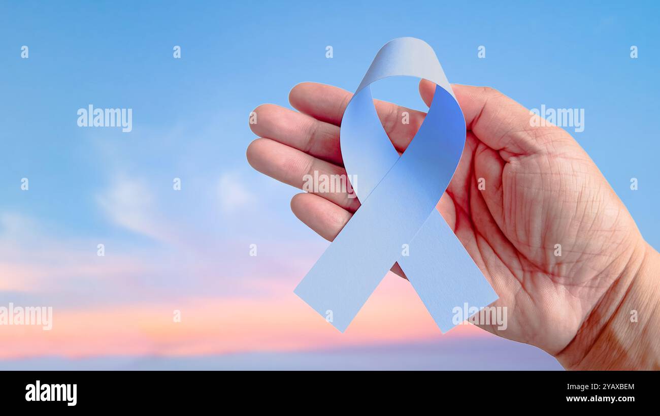 Hand holding blue ribbon, symbolizing prostrate cancer awareness ...