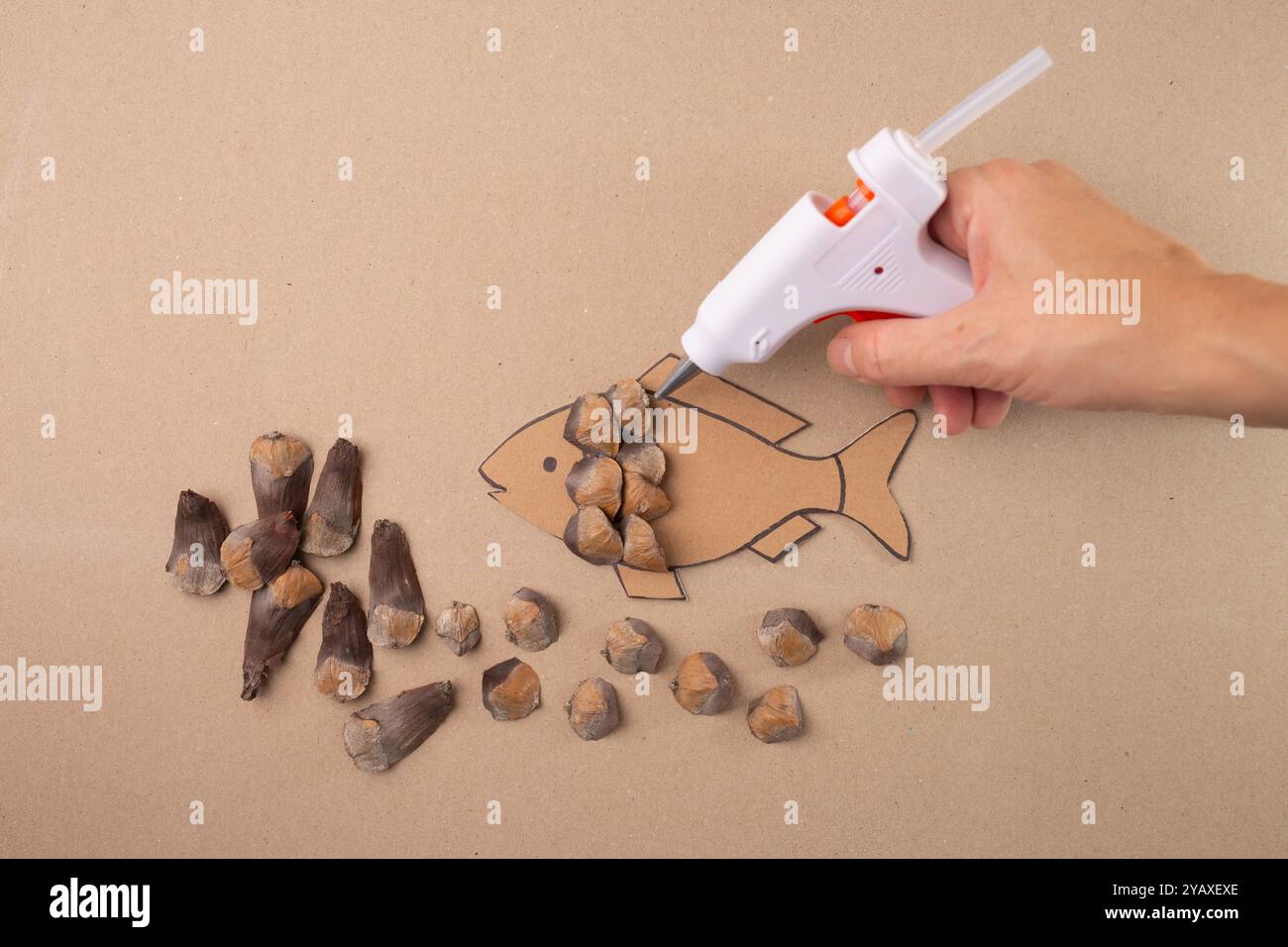 Fish formed with pine cones seed scales on beige. Nature art flat lay ...