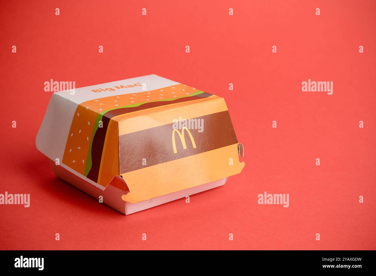 London, United Kingdom, 14th October 2024:- A view of a McDonalds Big Mac box, against a red ...