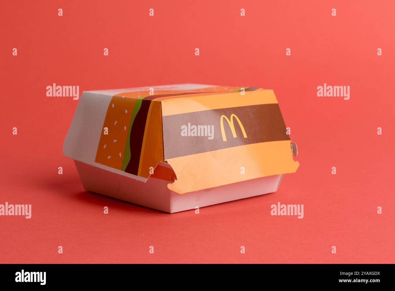 London, United Kingdom, 14th October 2024:- A view of a McDonalds Big Mac box, against a red ...