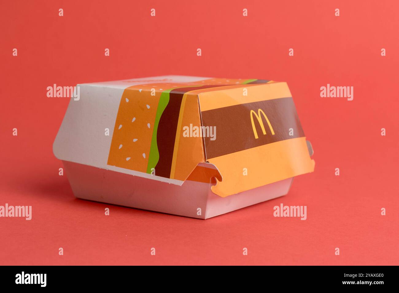London, United Kingdom, 14th October 2024:- A view of a McDonalds Big Mac box, against a red ...