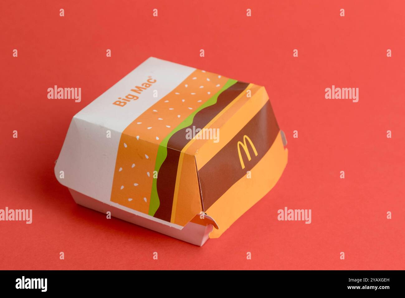 London, United Kingdom, 14th October 2024:- A view of a McDonalds Big Mac box, against a red ...