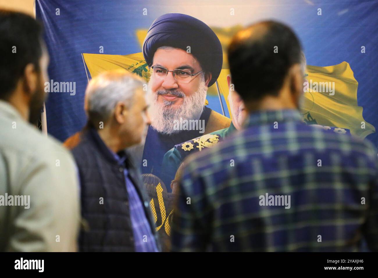 Tehran, Iran. 15th Oct, 2024. Iranians stand next to a portrait of the ...