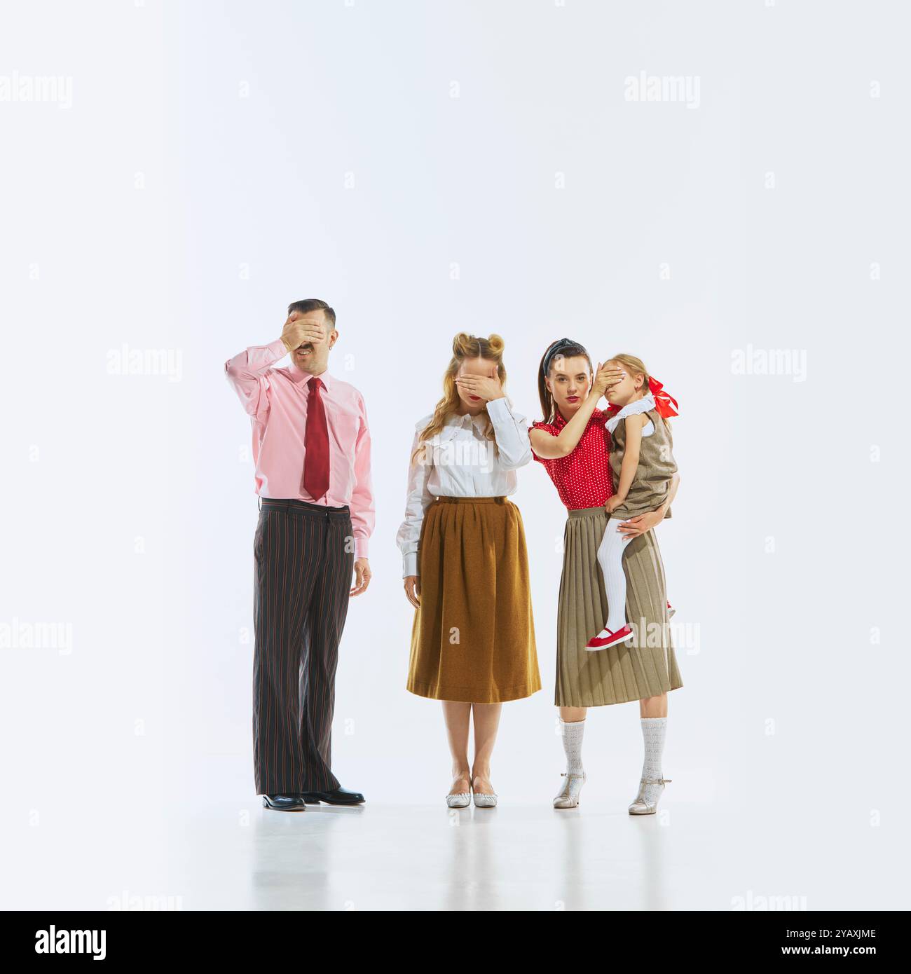 Three people, including young girl, covering their eyes in synchronized ...