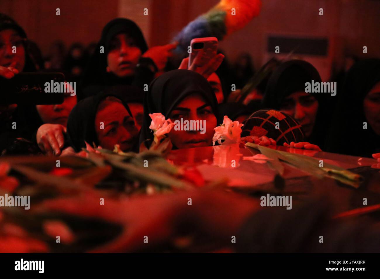 Tehran, Iran. 15th Oct, 2024. Mourners gather around the coffin of ...