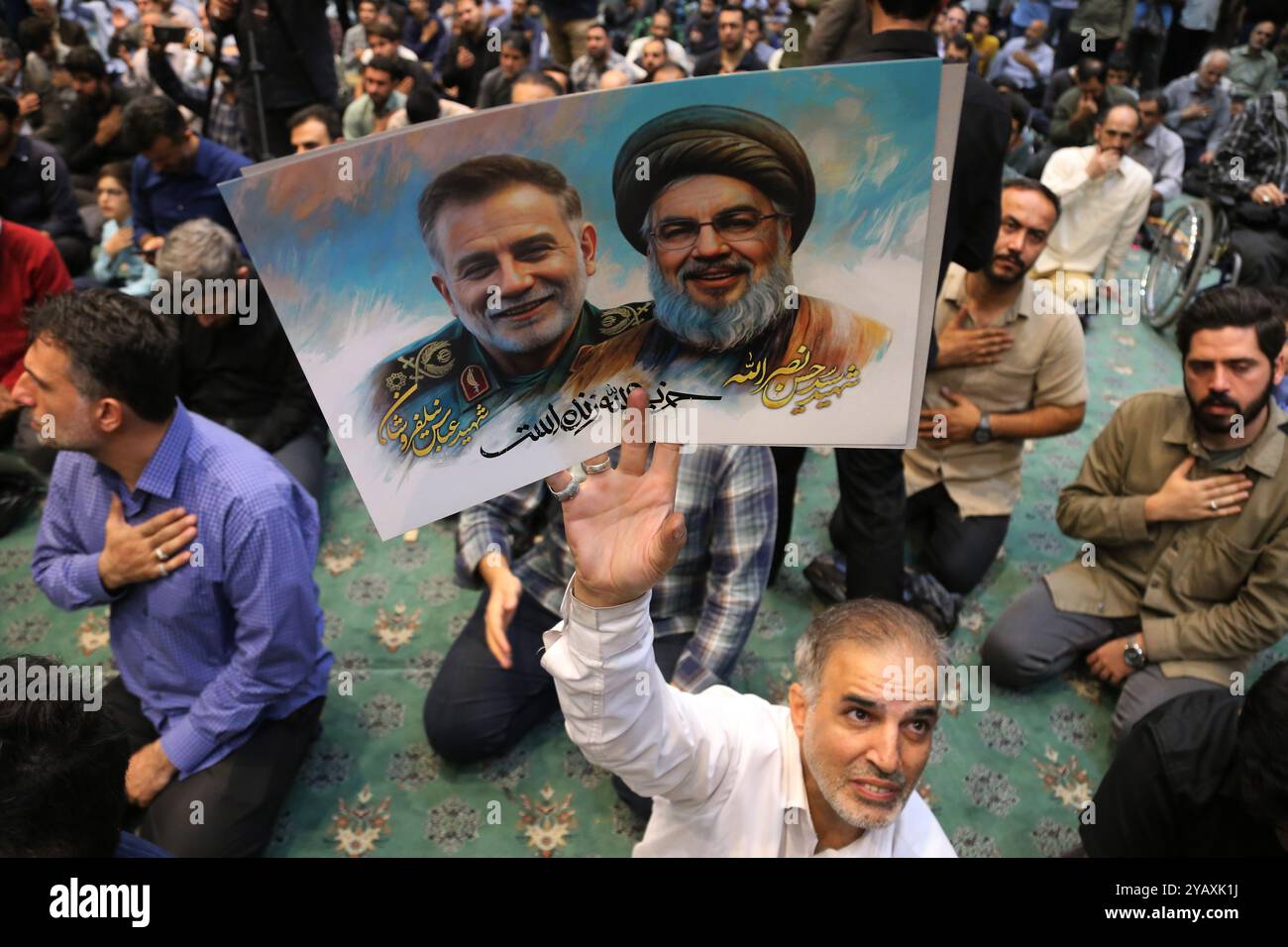 Tehran, Iran. 15th Oct, 2024. An Iranian man holds up a poster of the ...