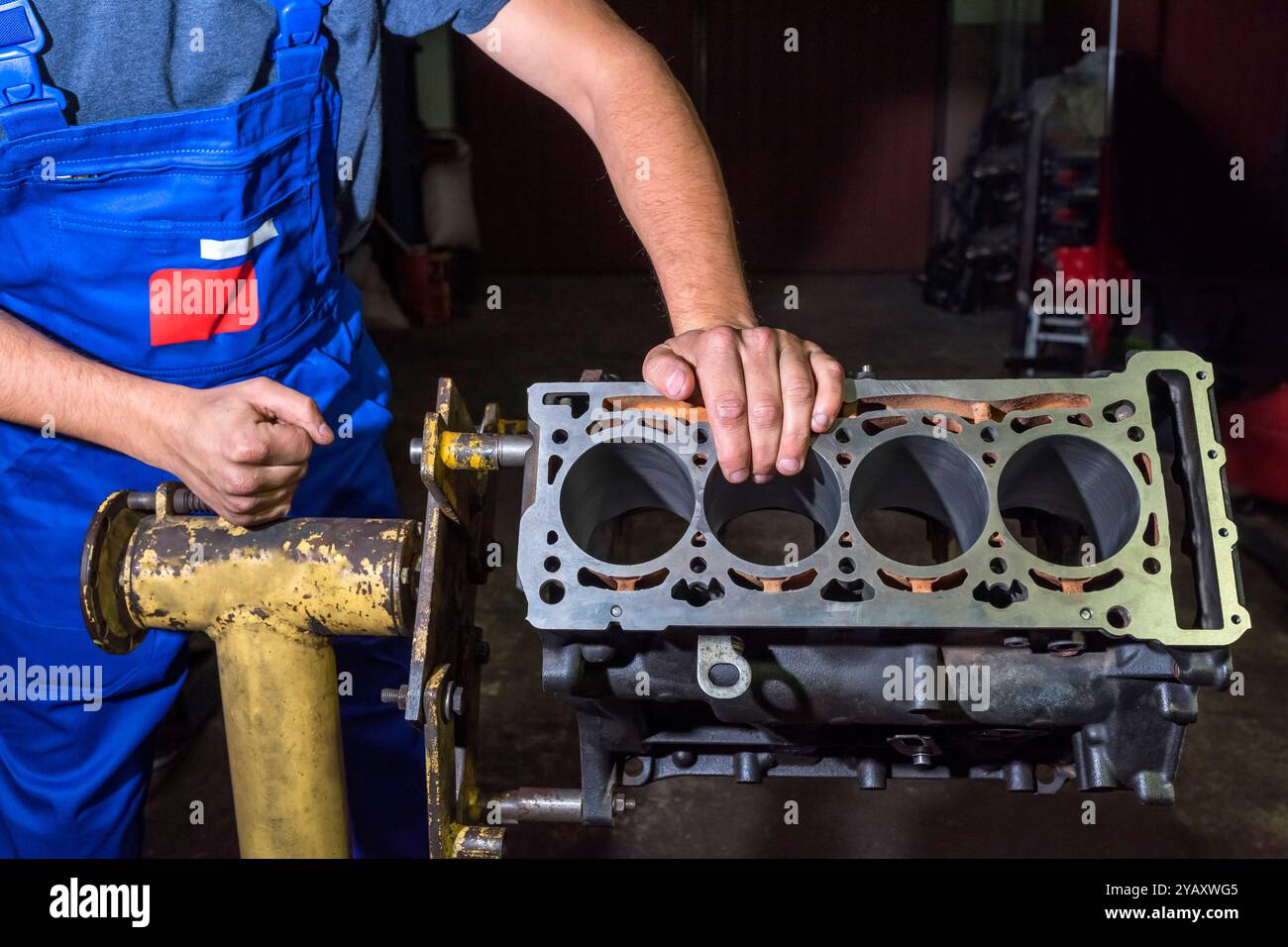 Auto mechanic repairing a cylinder block in a garage. Auto repair ...