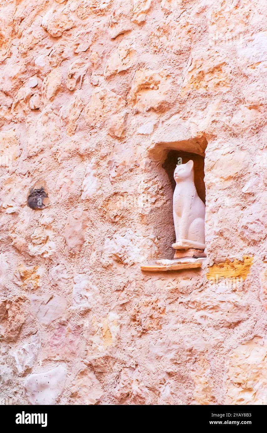 The beautiful sculpture of a cat in the niche of medieval wall of the ...