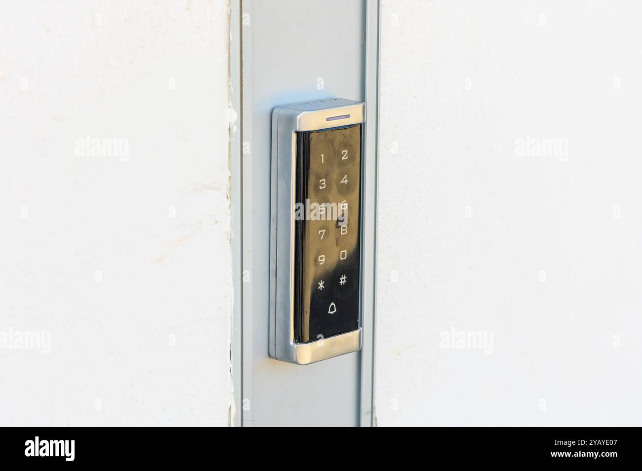 A sleek electronic keypad entry system is mounted on a metal door ...
