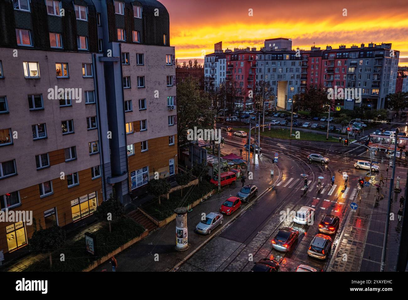 A vibrant city scene of a busy intersection during sunset. Cars and ...