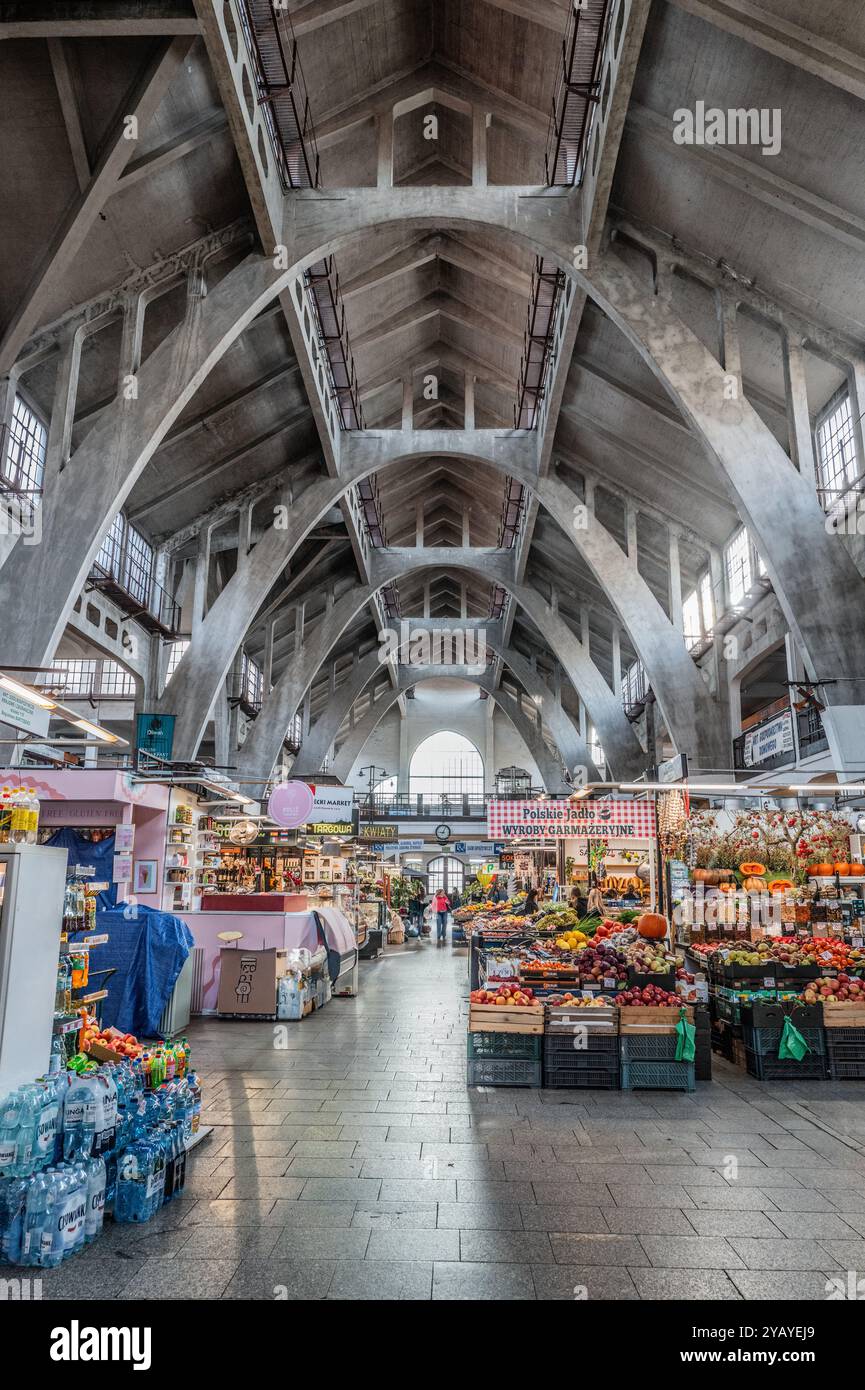 A bustling indoor market with high ceilings, showcasing vibrant stalls ...