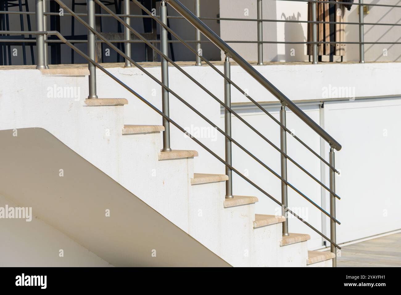 A contemporary staircase features smooth, light-colored steps and ...