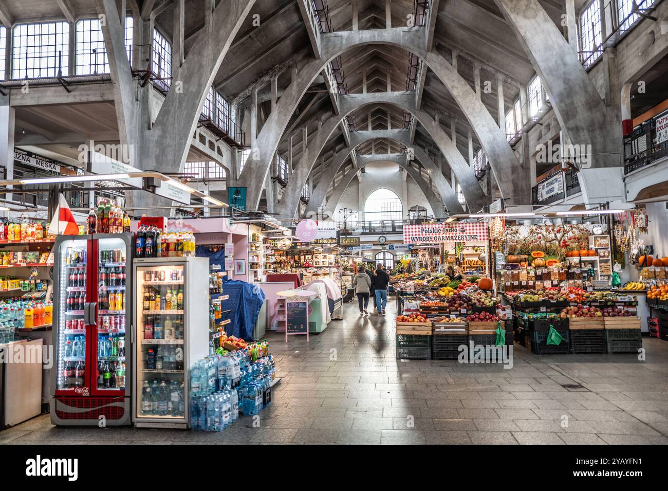 A bustling indoor market with high ceilings, showcasing vibrant stalls ...