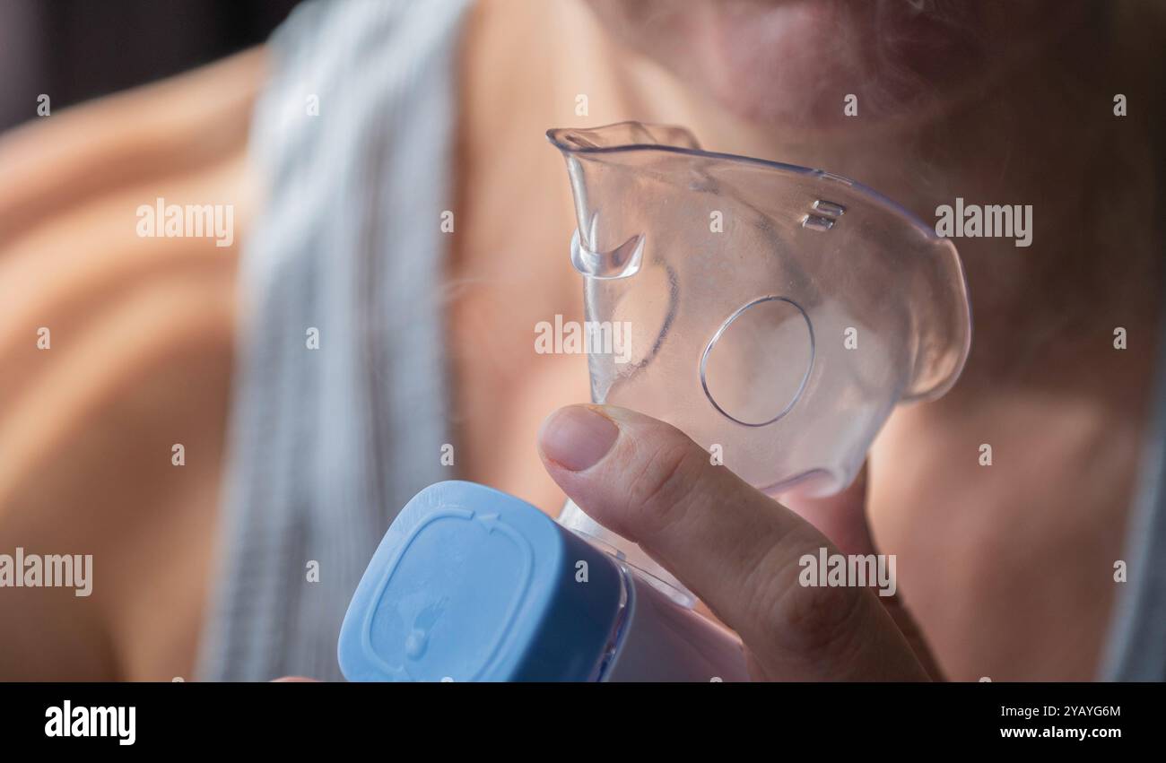Woman using a nebulizer mask.Inhalation therapy curing chest cold and ...