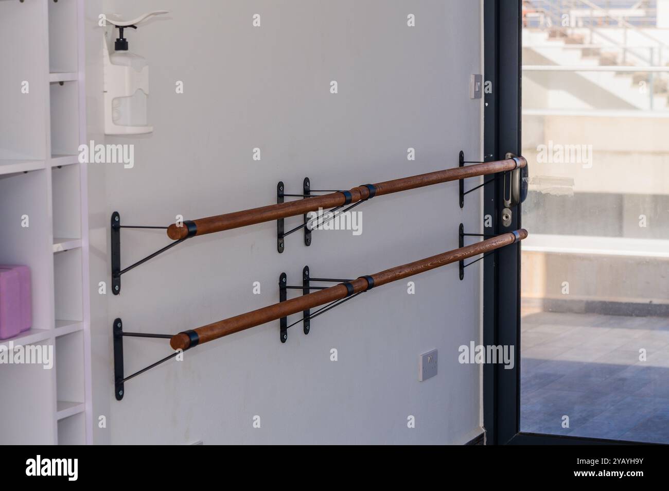 A beautifully crafted wooden ballet barre adorns a modern studio wall ...