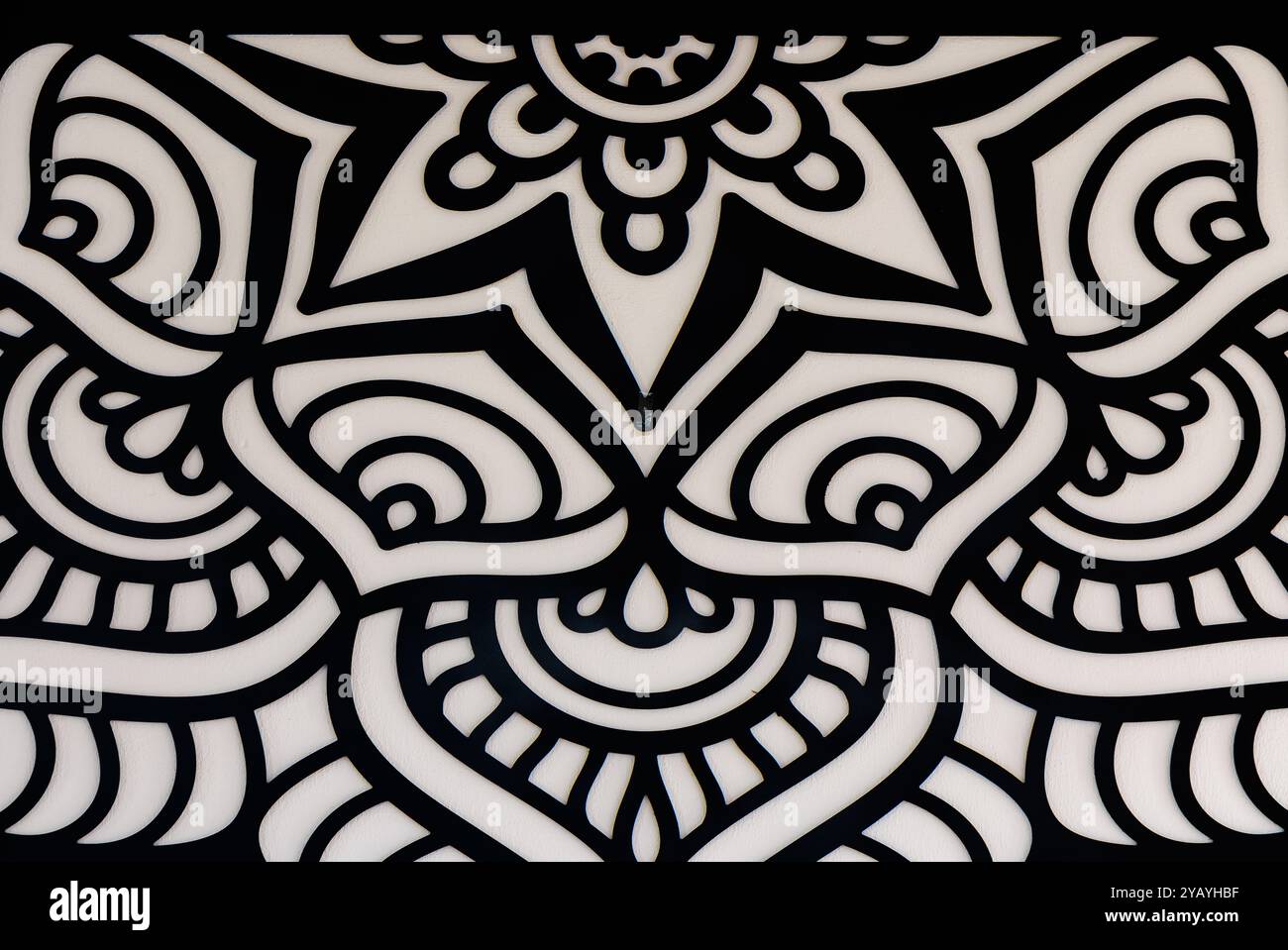 An elaborate mandala design features flowing swirls and shapes ...