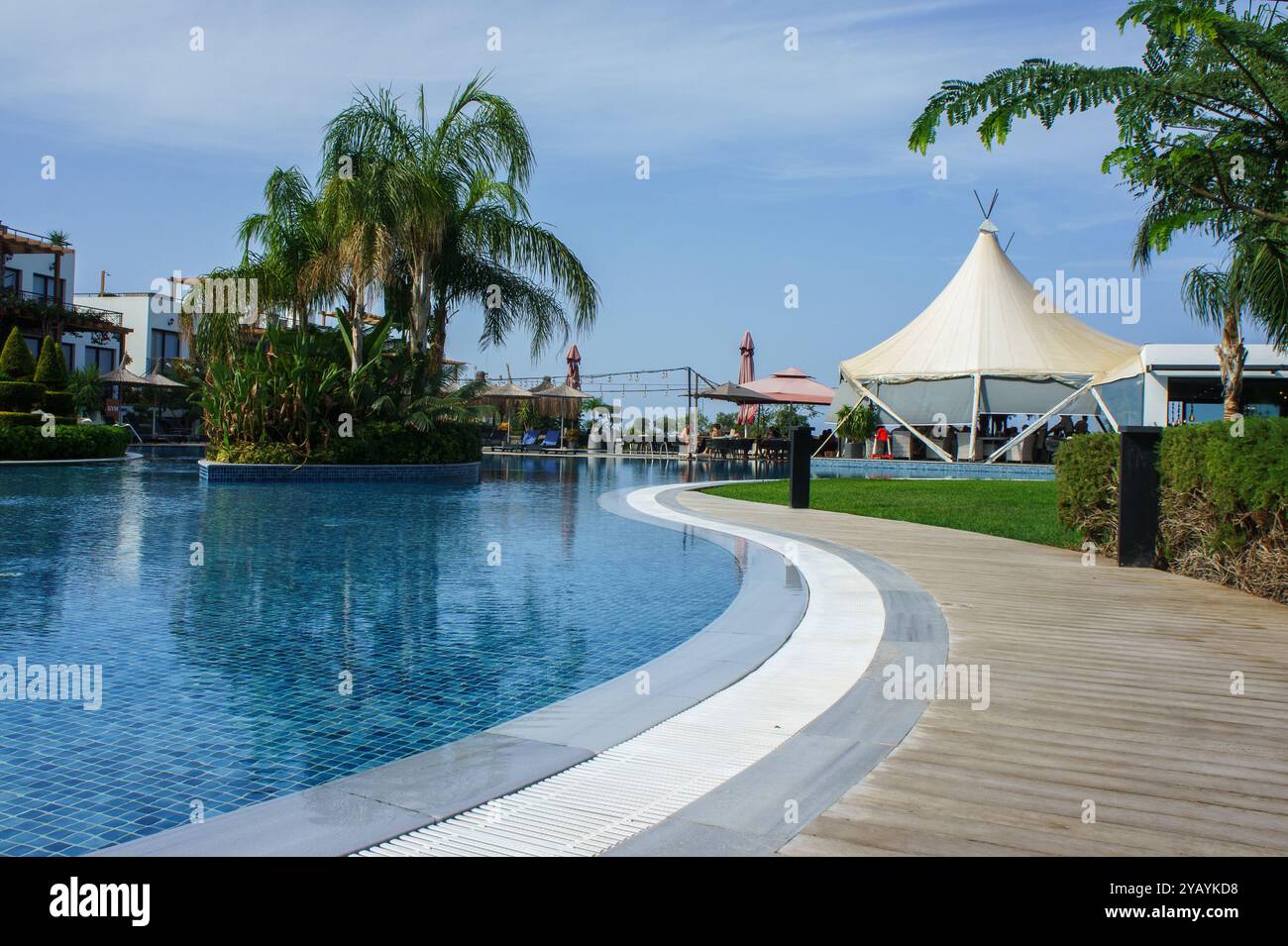 Glorious sunshine illuminates the resort's inviting pool, framed by ...