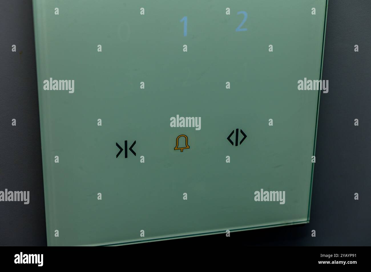 A sleek elevator control panel features illuminated numbers and icons ...