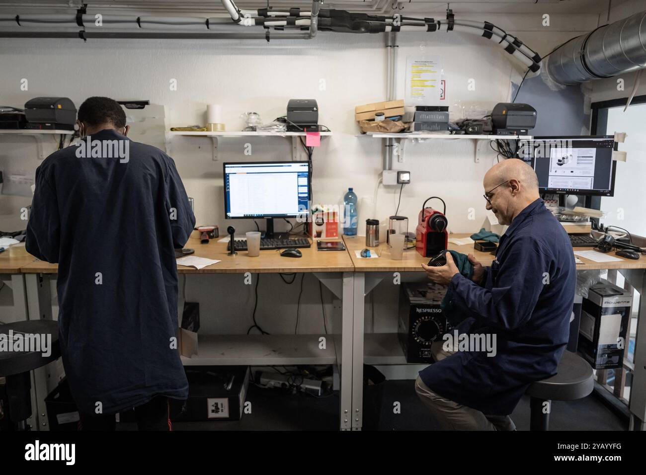 Employees repairing faulty products in a RepareSeb workshop, dedicated ...
