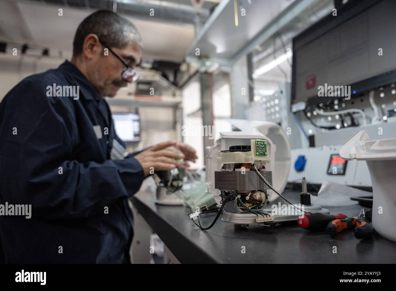 An employee repairing a faulty product in a RepareSeb workshop ...