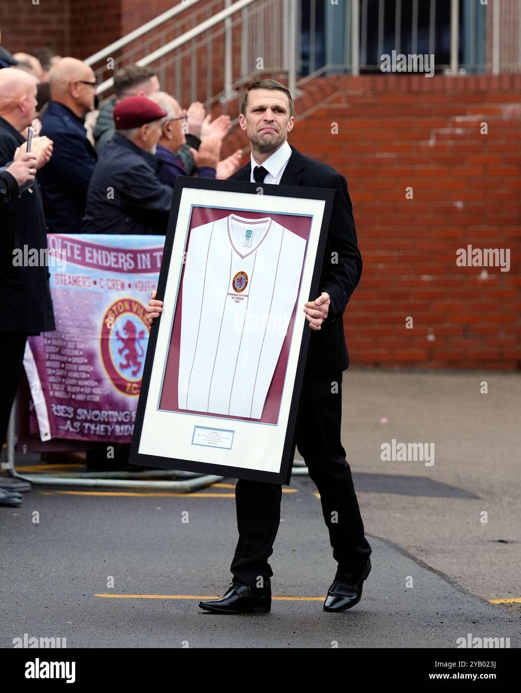 A mourner carries an Aston Villa shirt worn by Gary Shaw, as the ...