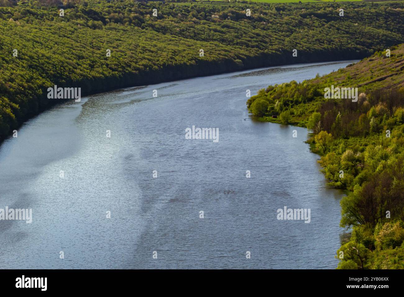 wide river in green banks overgrown with woods Stock Photo - Alamy
