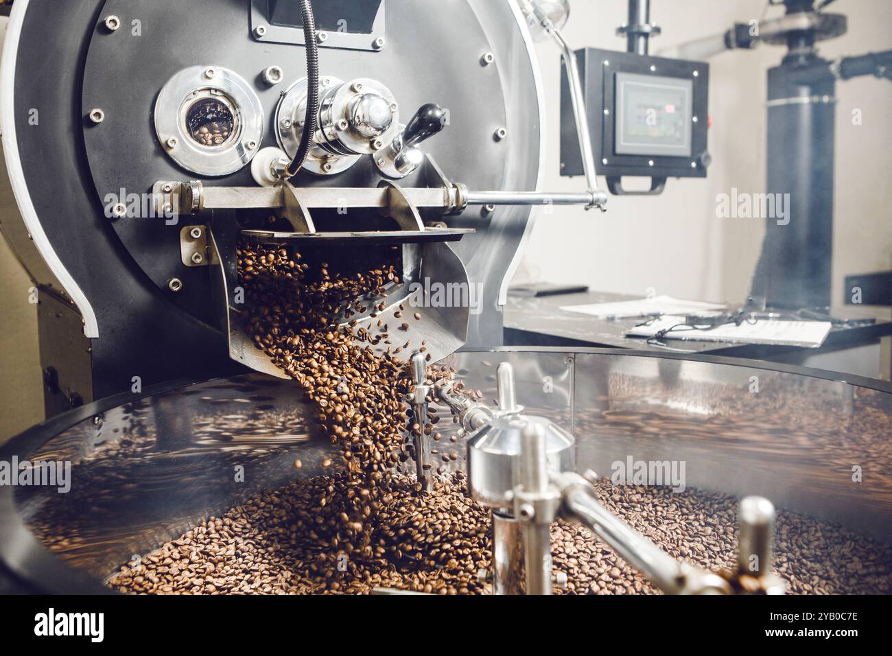 Filling out of freshly roasted coffee beans from large coffee roaster ...