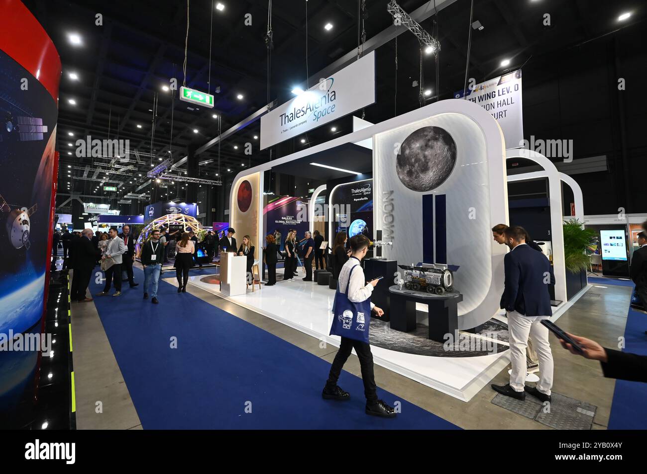 Visitors walk past the Thales Alenia Space exhibitor booth during the ...