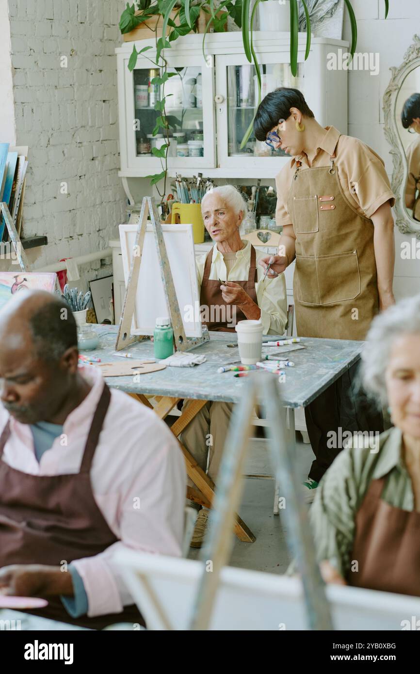 Vertical shot of young adult drawing teacher checking her senior ...